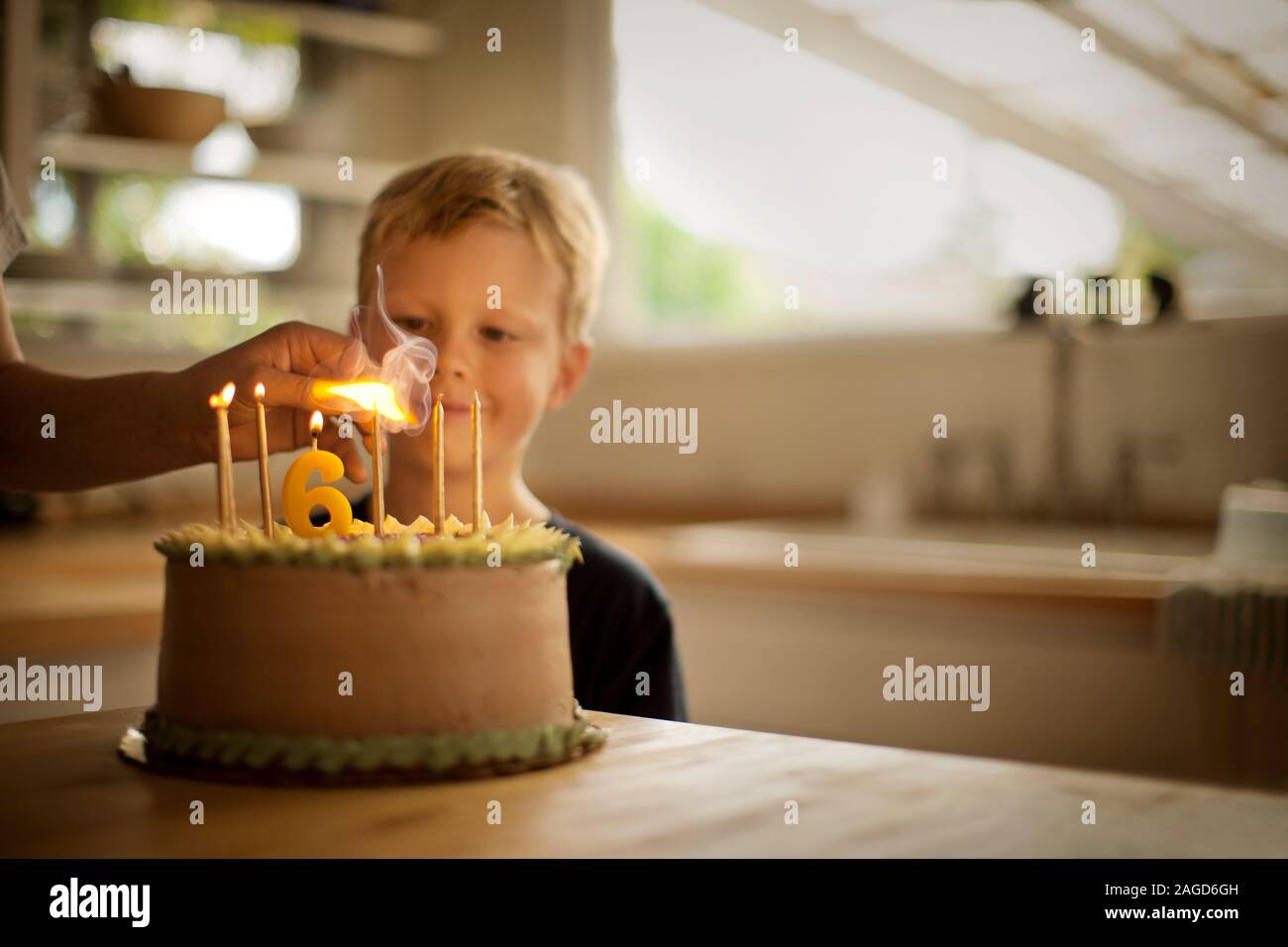 Happy young boy blowing out candles on a birthday cake Stock Photo - Alamy