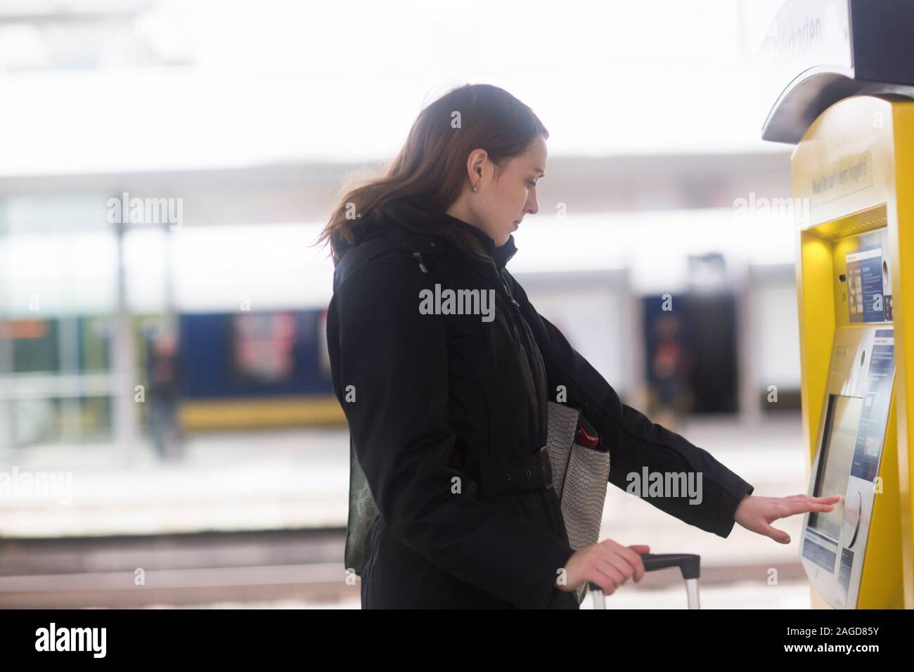 Young woman at ticket machine in train terminal Stock Photo - Alamy