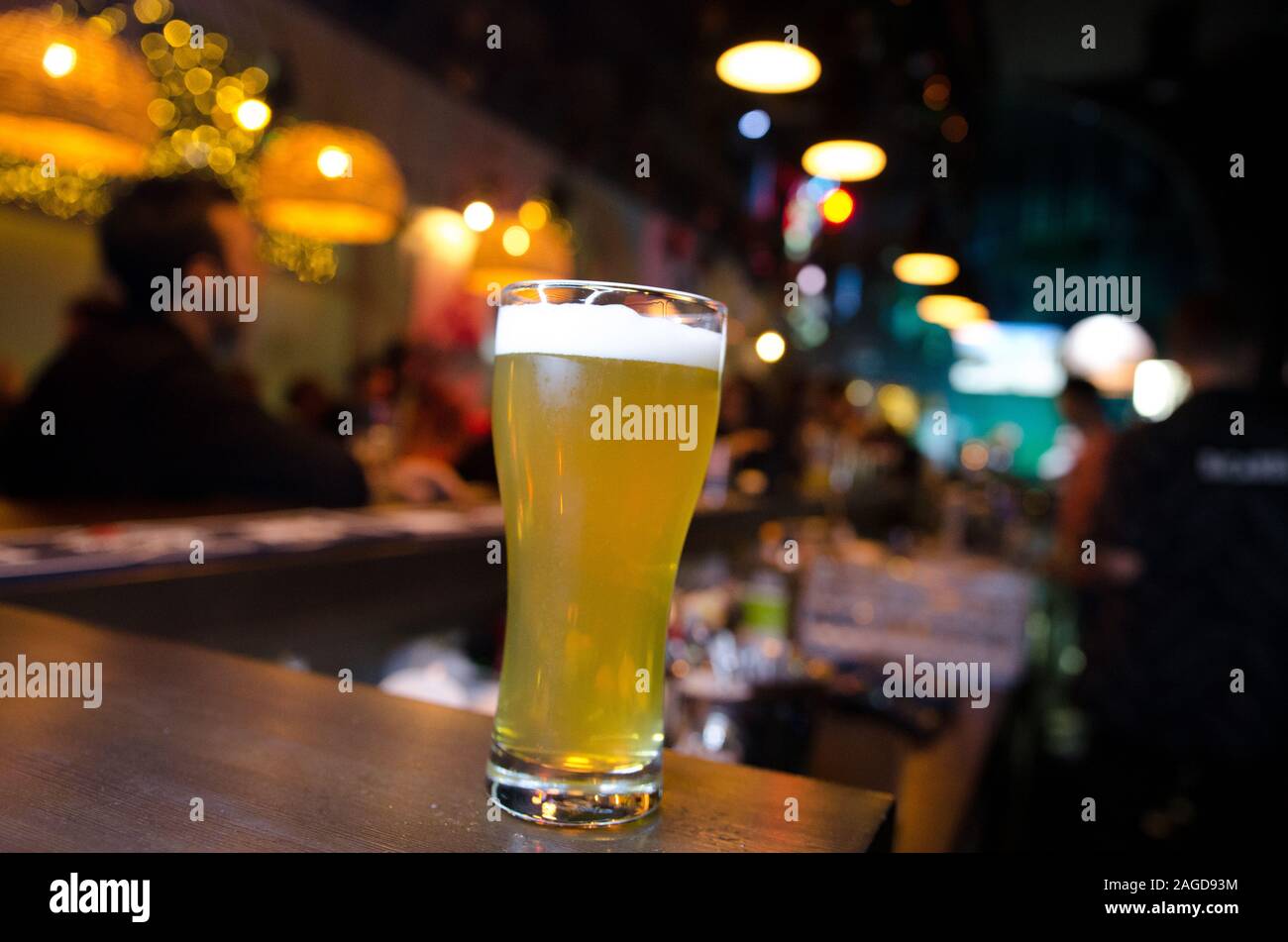 Glasses of light beer on a pub counter. Pub blurred background. Party ...
