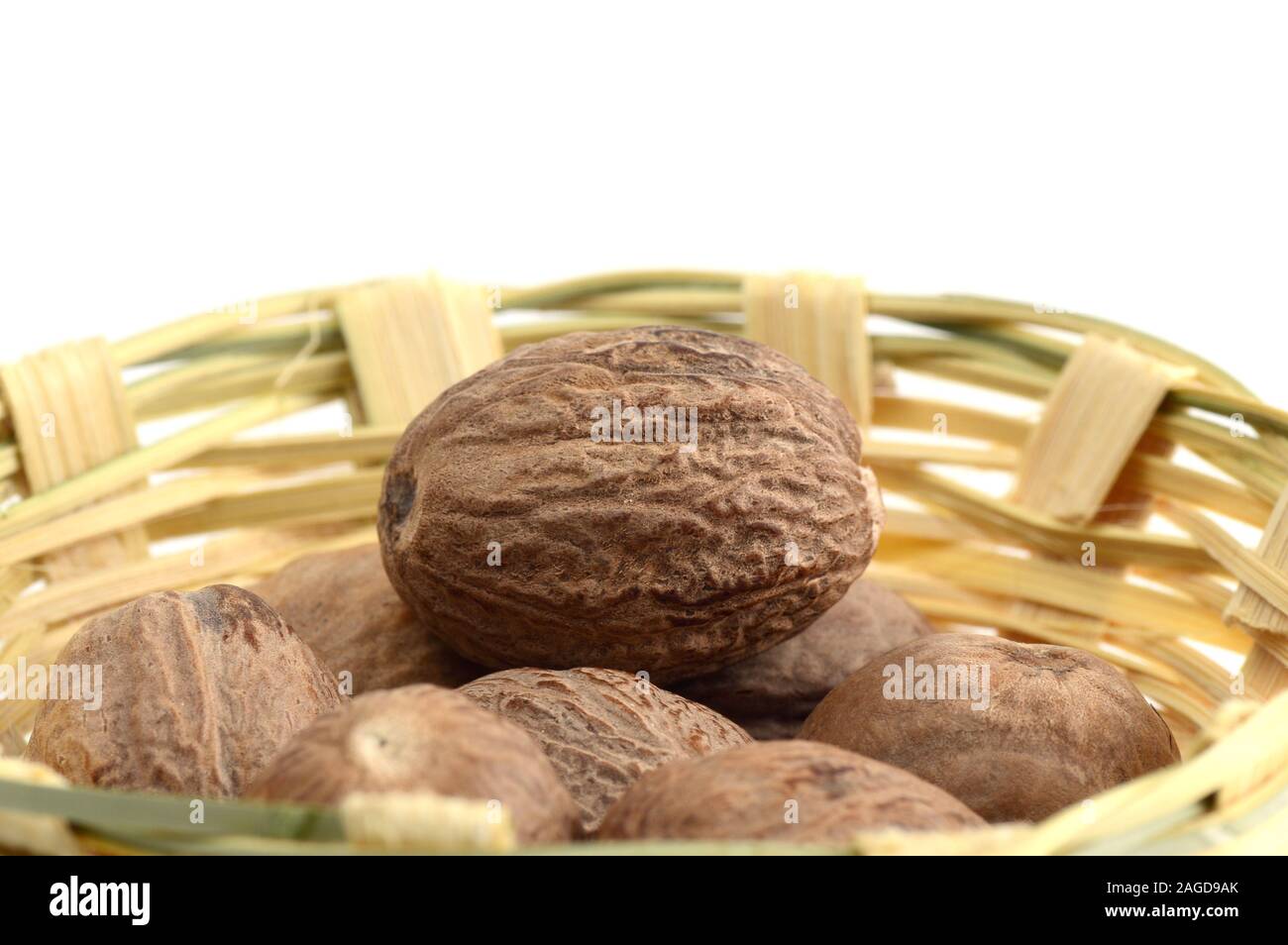 Nutmeg in bamboo basket isolated on white background Stock Photo - Alamy