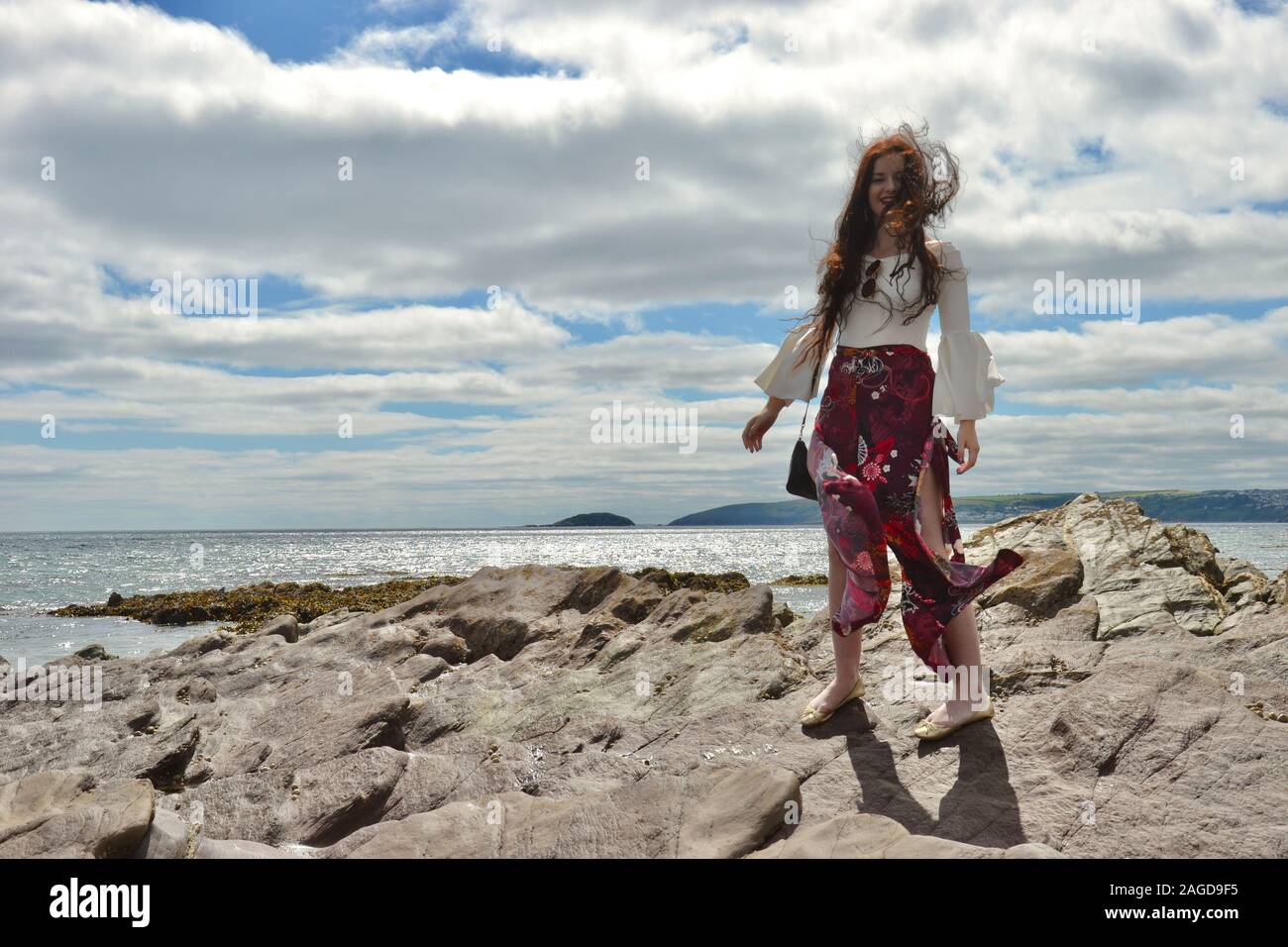 Hippie fashionable young lady with long brown hair and floral flared ...