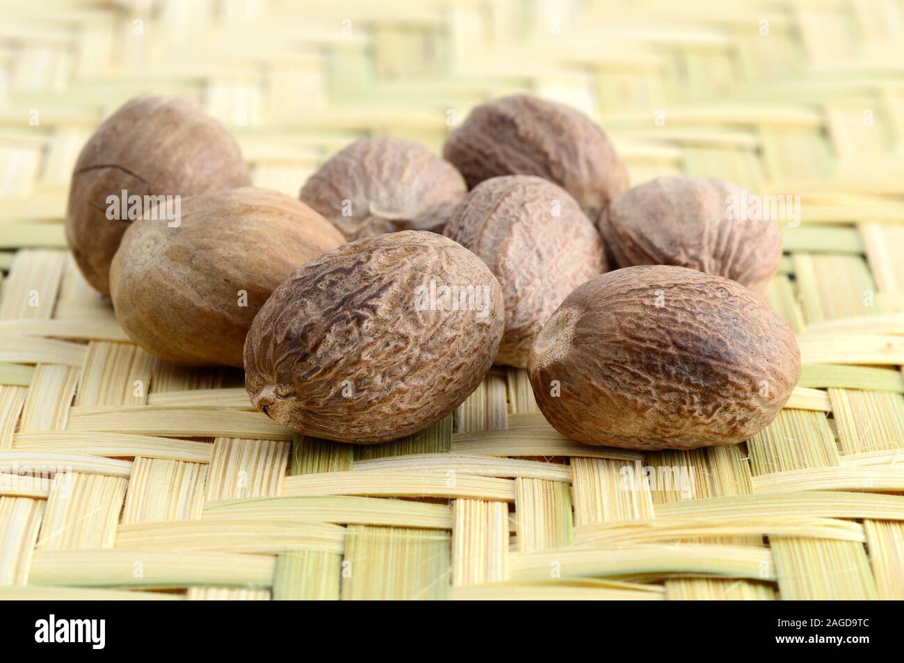 Nutmeg in bamboo basket isolated on white background Stock Photo - Alamy