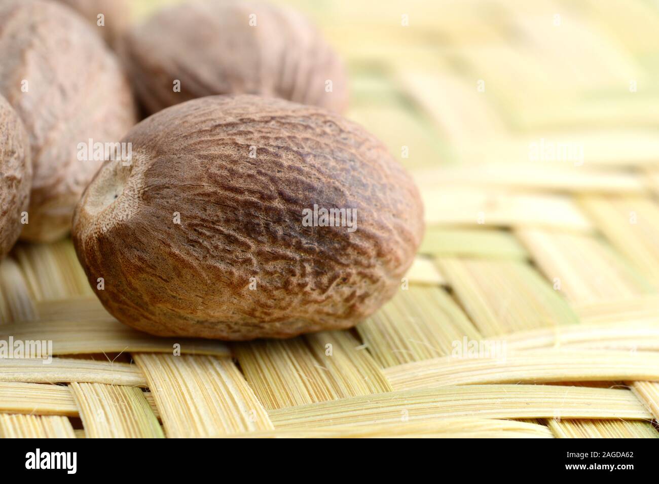 Nutmeg in bamboo basket isolated on white background Stock Photo - Alamy