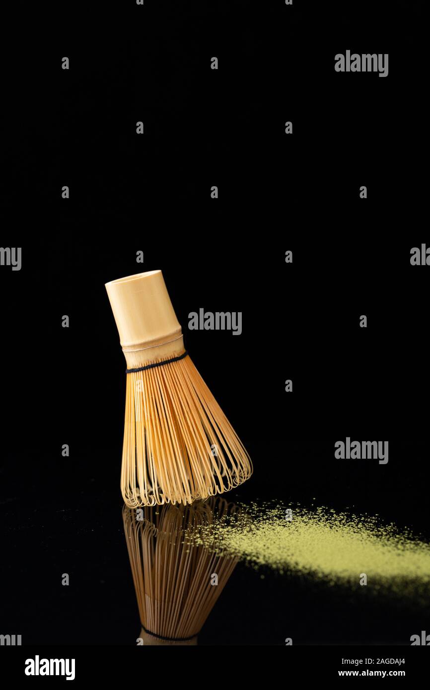 Vertical shot of a small broom sweeping the yellow dust on black ...