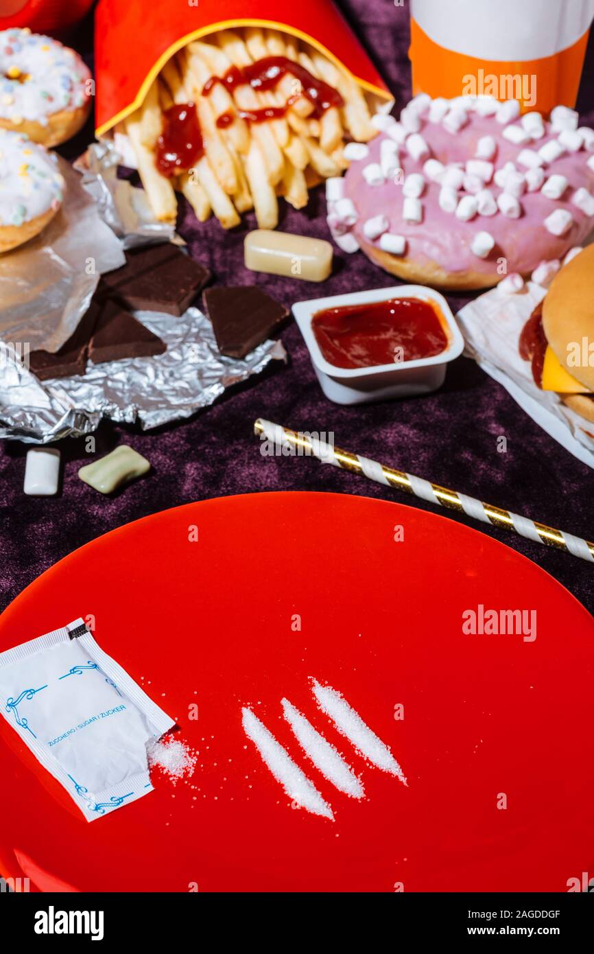 Sugar arranged as cocaine stripes, with junk fast food. Addiction ...