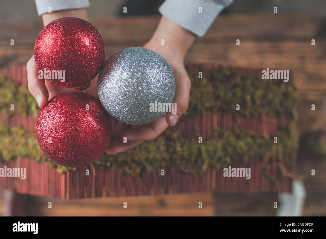 High angle closeup shot of human palms holding three red and silver ...