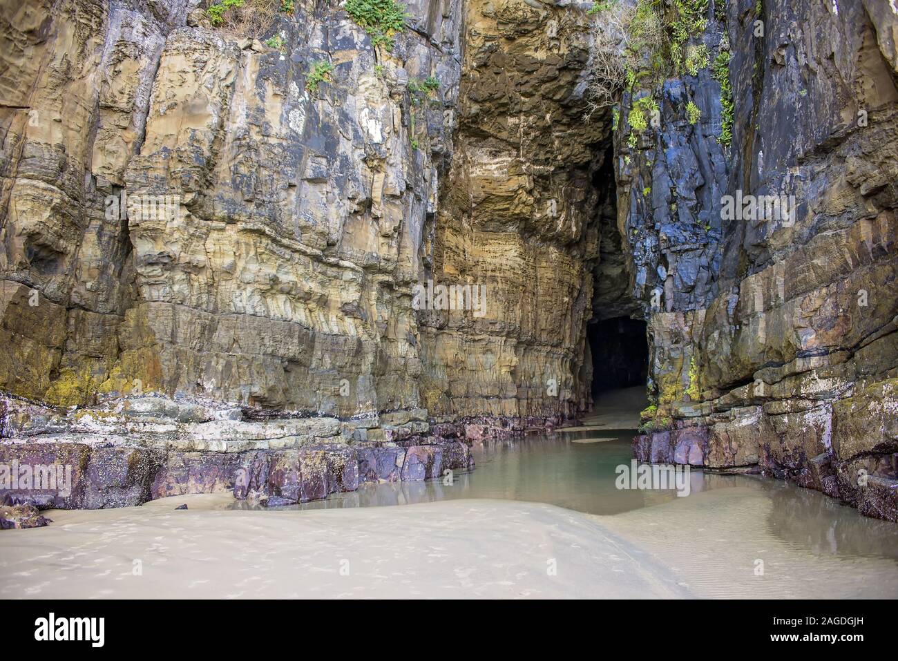 Landscape of a cave with high stone walls covered in greenery ...