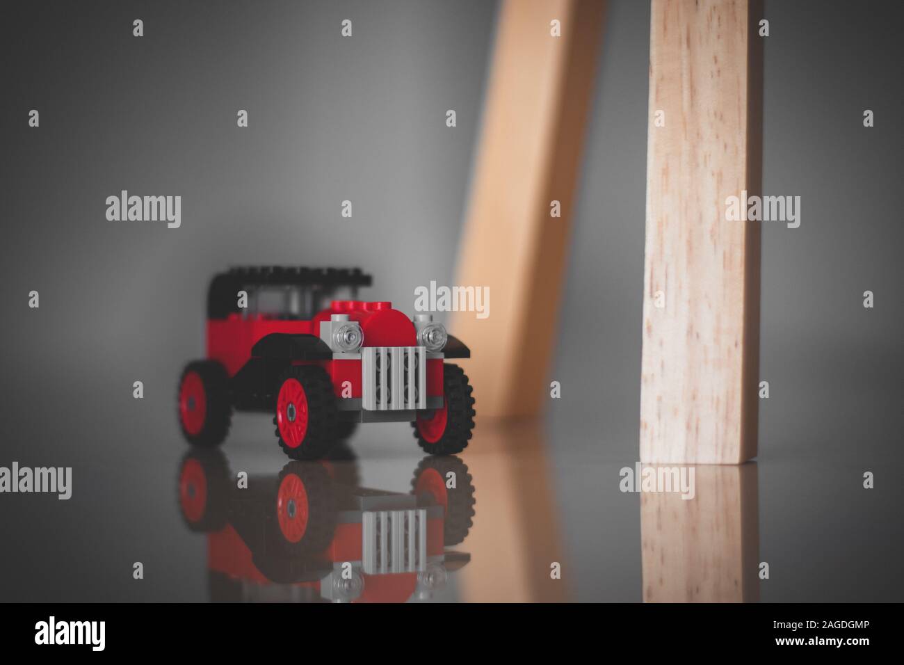 Closeup picture of a red and black toy car on a table with its ...