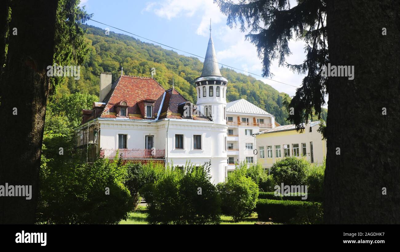 Manor house with white walls and a red roof in a garden surrounded by ...