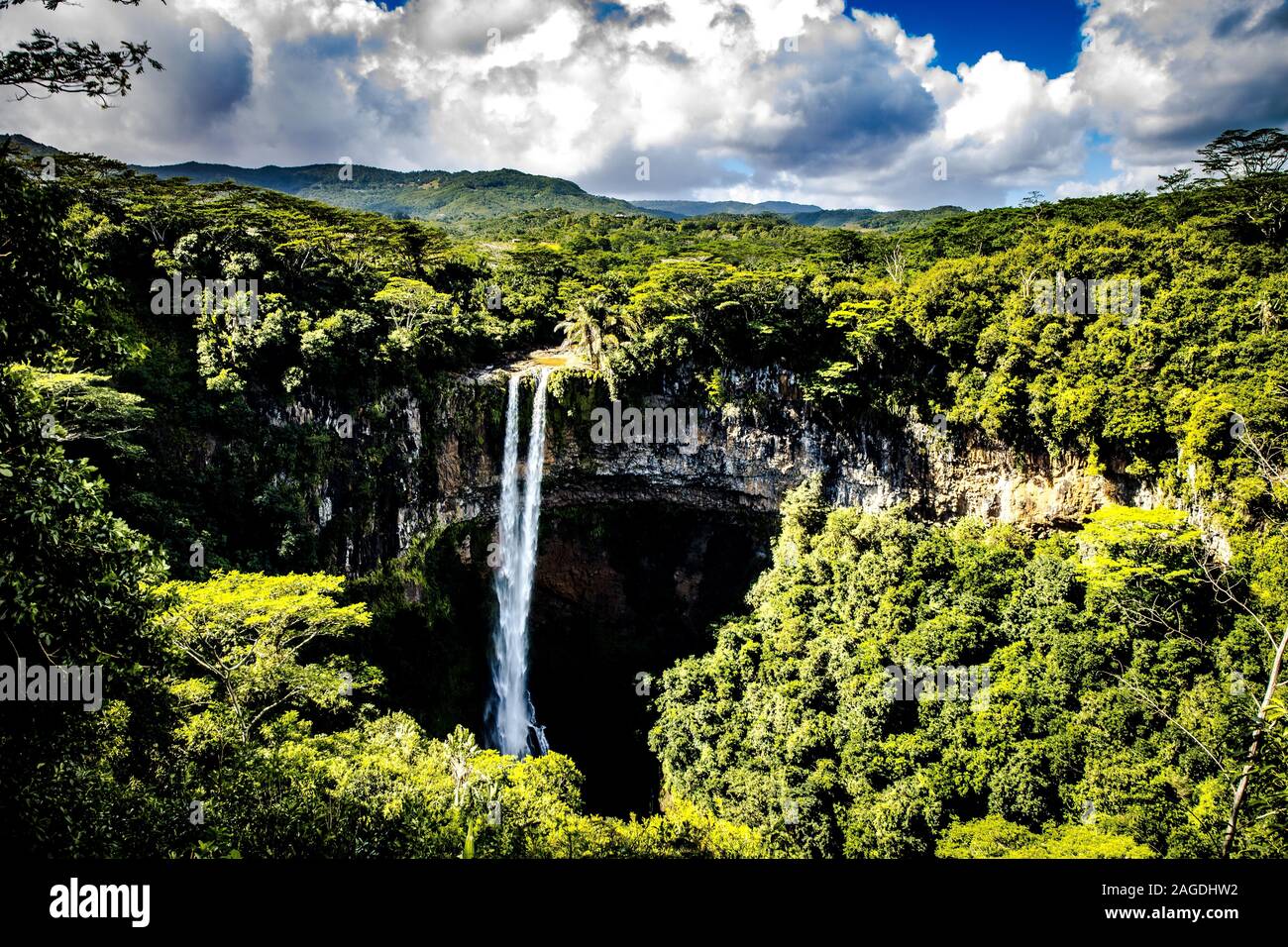 Landscape of the Chamarel waterfall surrounded by rocks and forests ...