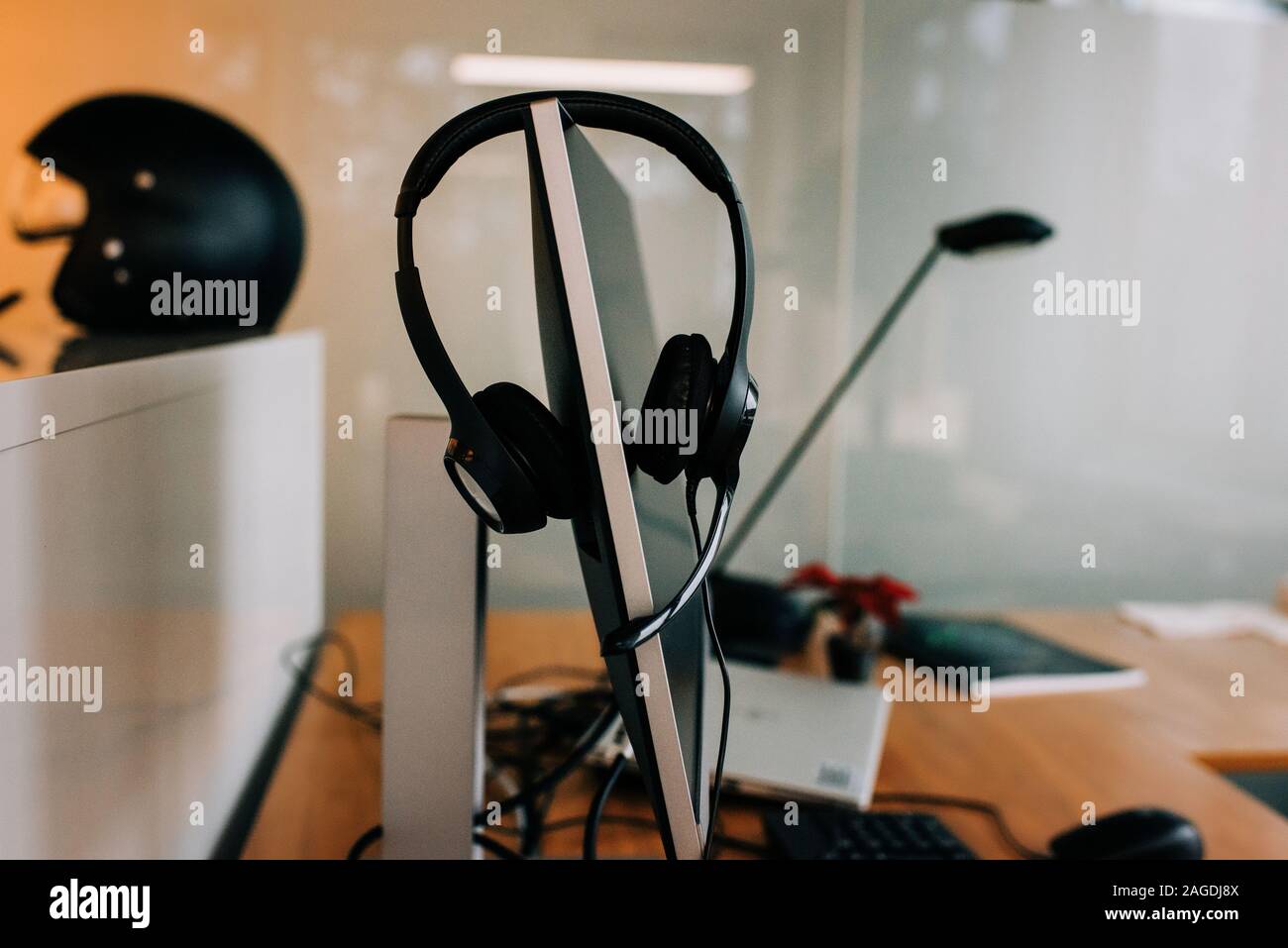 headphone set sitting on a computer at a desk in an office Stock Photo ...