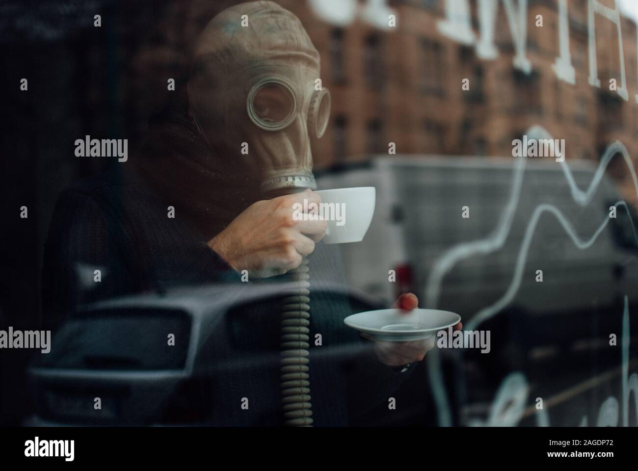 Person with a respirator drinking coffee in a cafe - emphasizes air ...