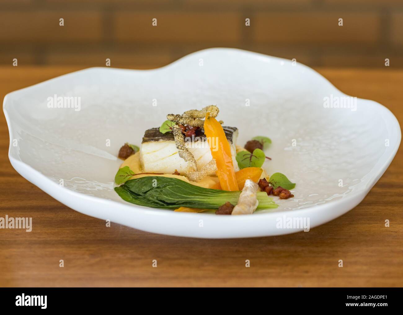 Delicious fish dish made with different kinds of vegetables on a wooden ...