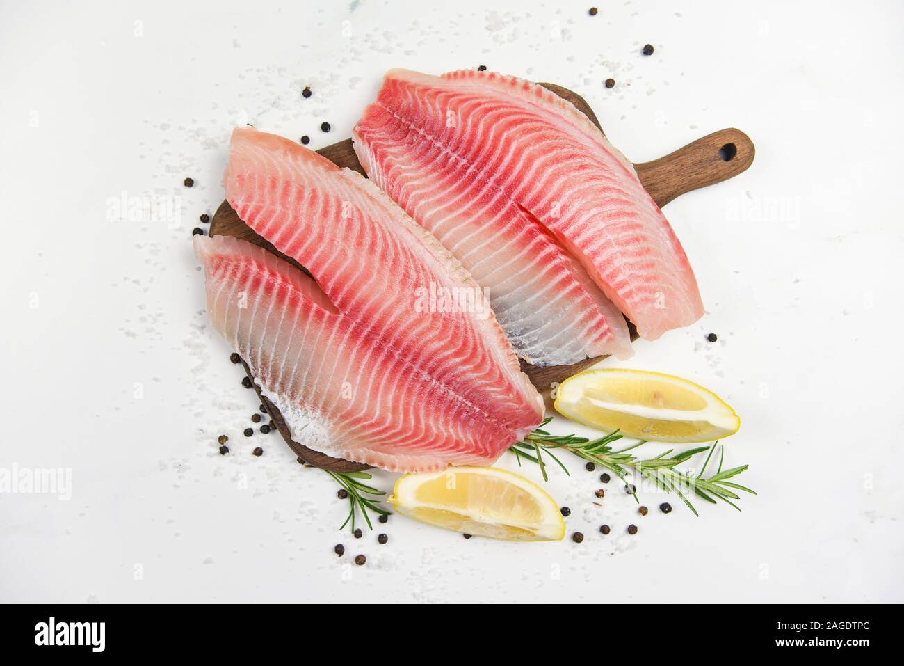 Fresh fish fillet sliced for steak or salad with herbs spices rosemary ...