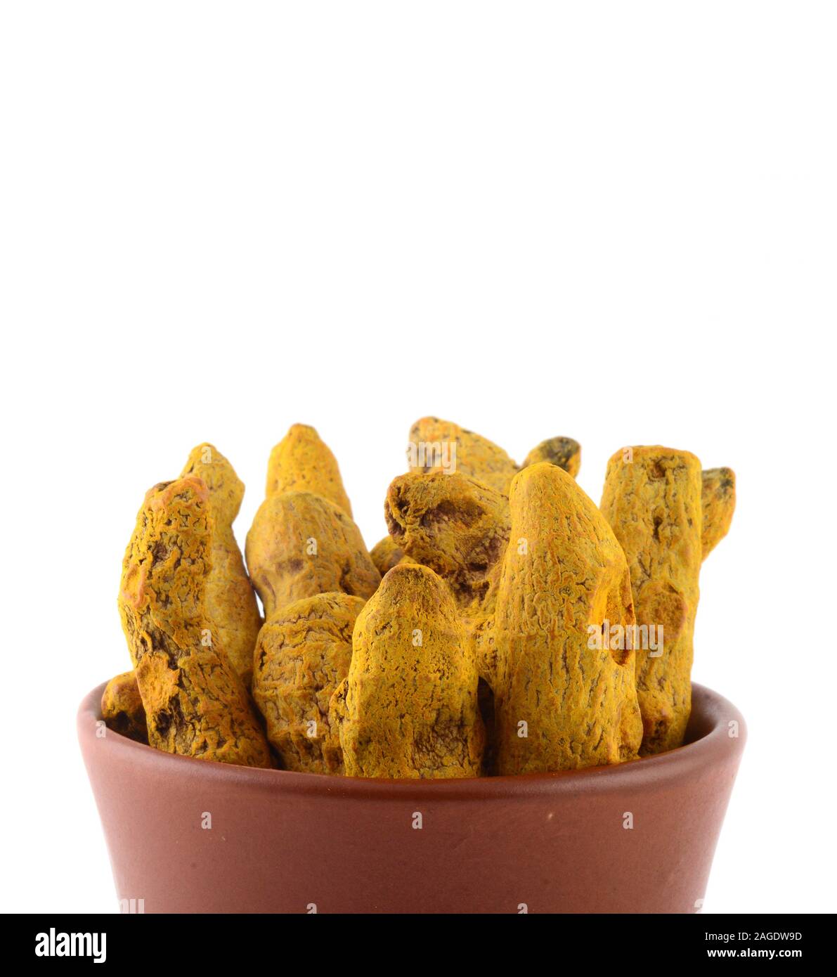 Dry Turmeric roots or barks in clay pot isolated on white background ...