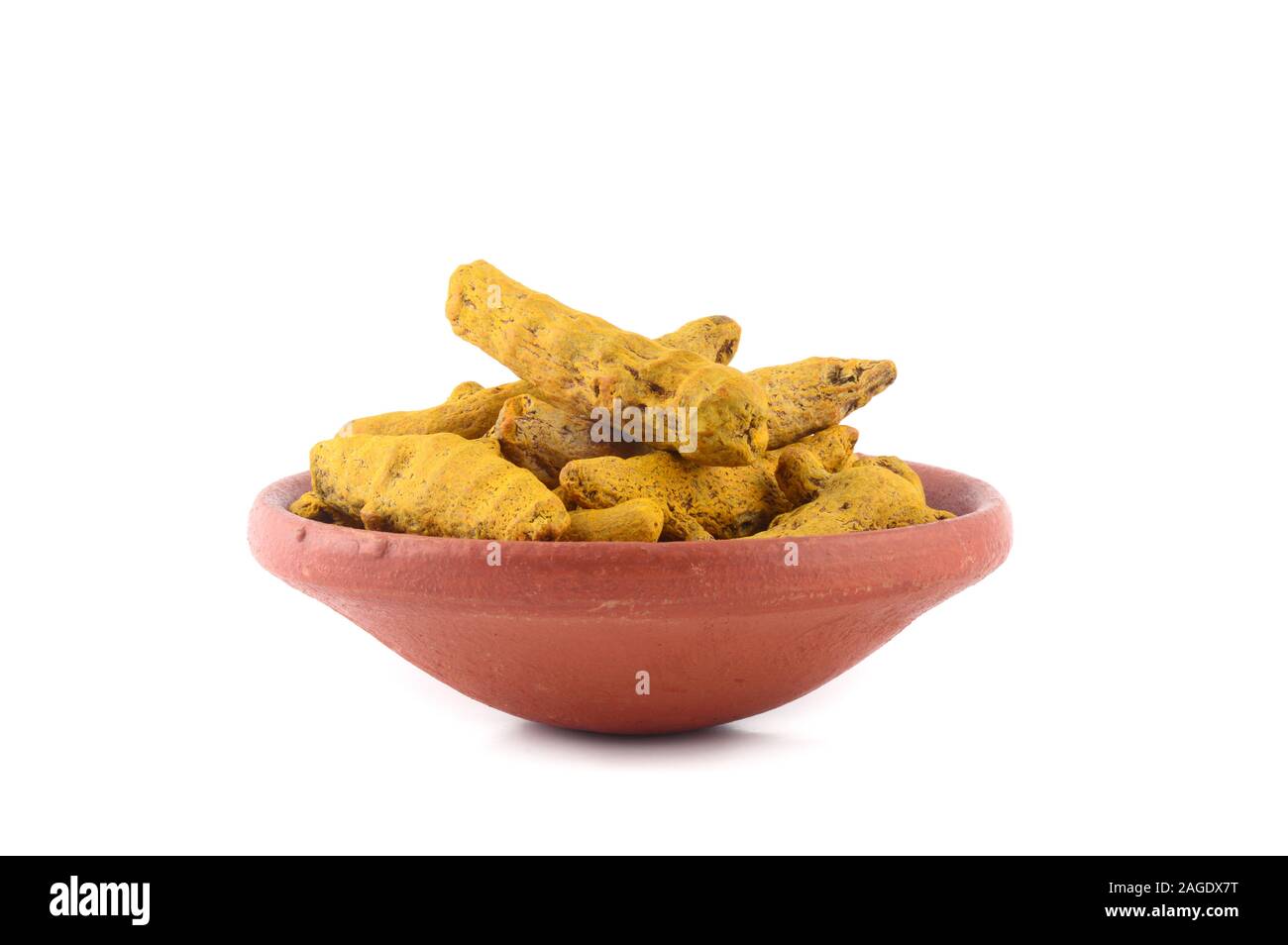 Dry Turmeric roots or barks in clay pot isolated on white background ...