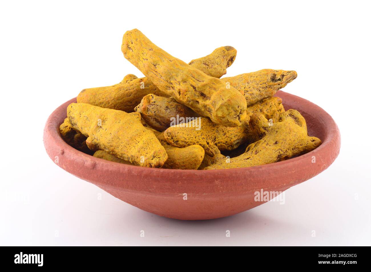 Dry Turmeric roots or barks in clay pot isolated on white background ...