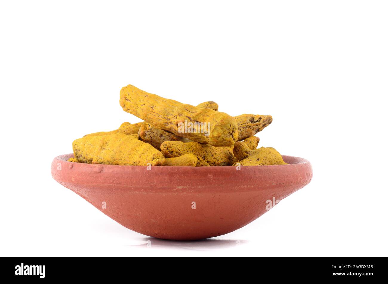 Dry Turmeric roots or barks in clay pot isolated on white background ...