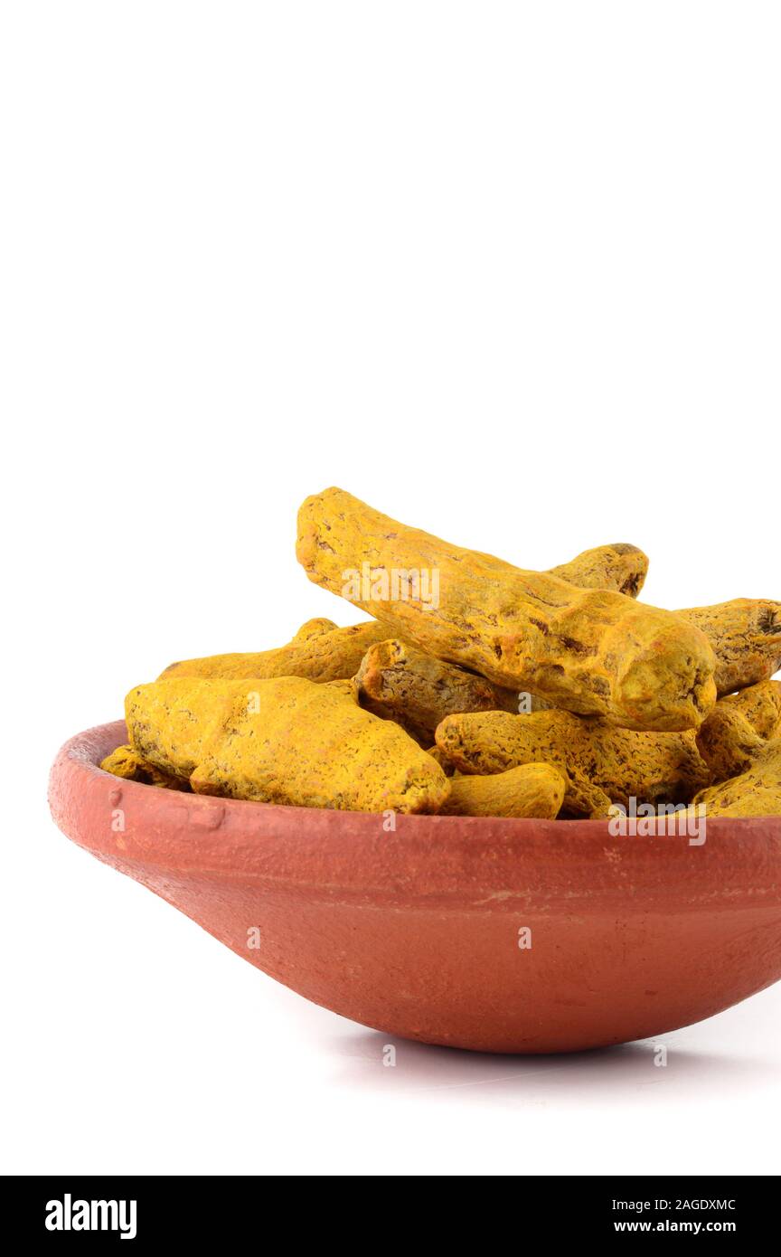 Dry Turmeric roots or barks in clay pot isolated on white background ...