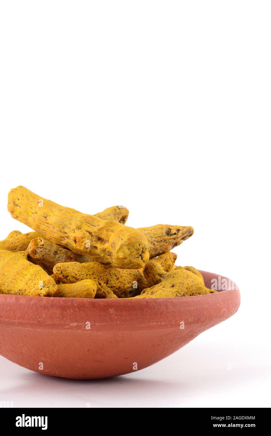 Dry Turmeric roots or barks in clay pot isolated on white background ...