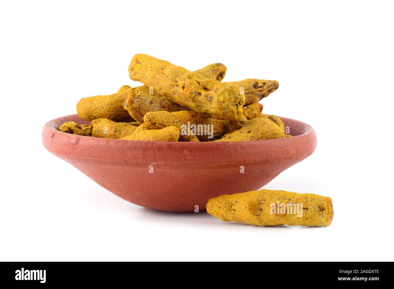Dry Turmeric roots or barks in clay pot isolated on white background ...