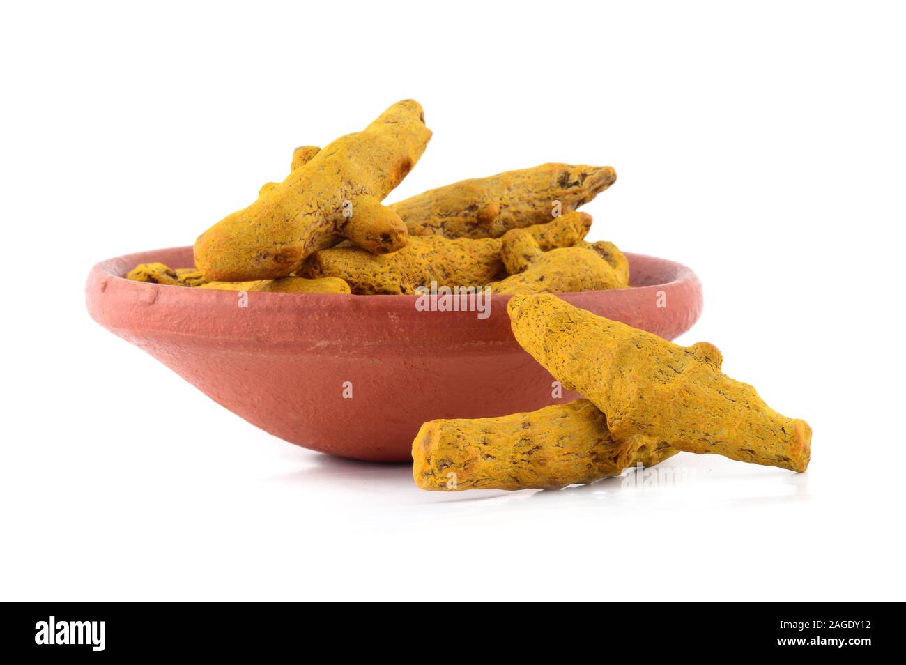 Dry Turmeric roots or barks in clay pot isolated on white background ...