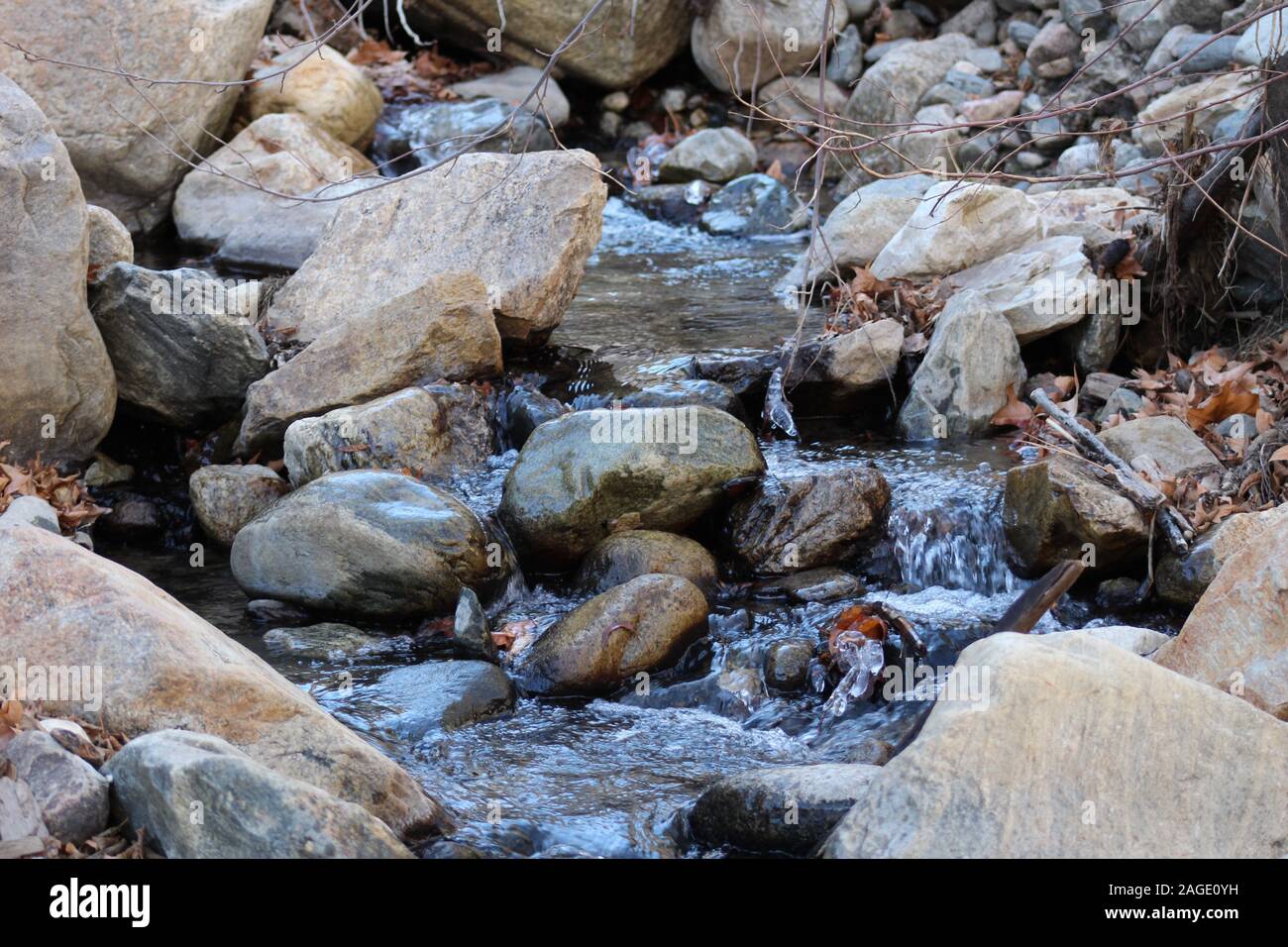 Small ravine flowing through an area with big stones Stock Photo - Alamy