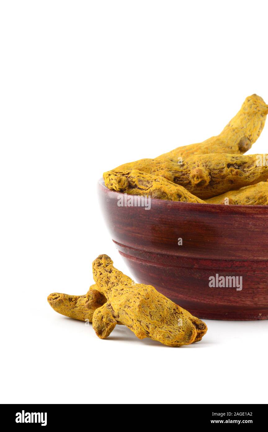 Dry Turmeric roots or barks in wooden bowl isolated on white background ...