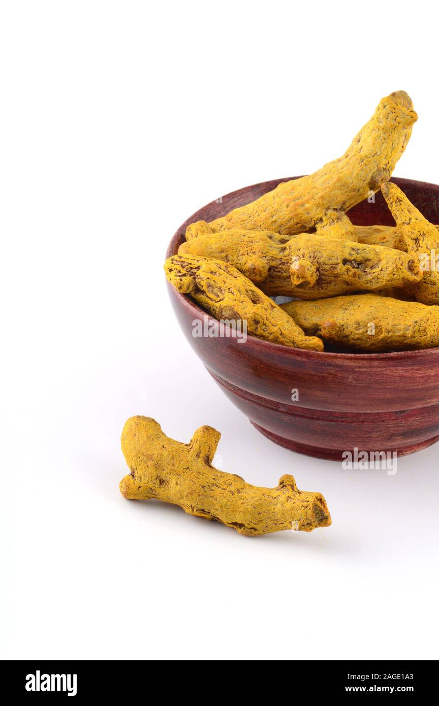 Dry Turmeric roots or barks in wooden bowl isolated on white background ...