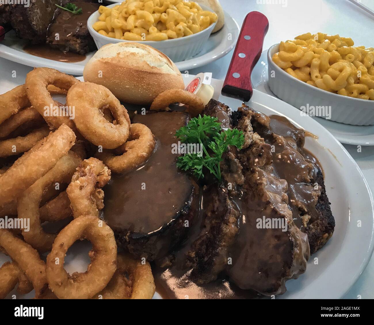 Plate full of roasted beef with an egg and onion rings Stock Photo - Alamy