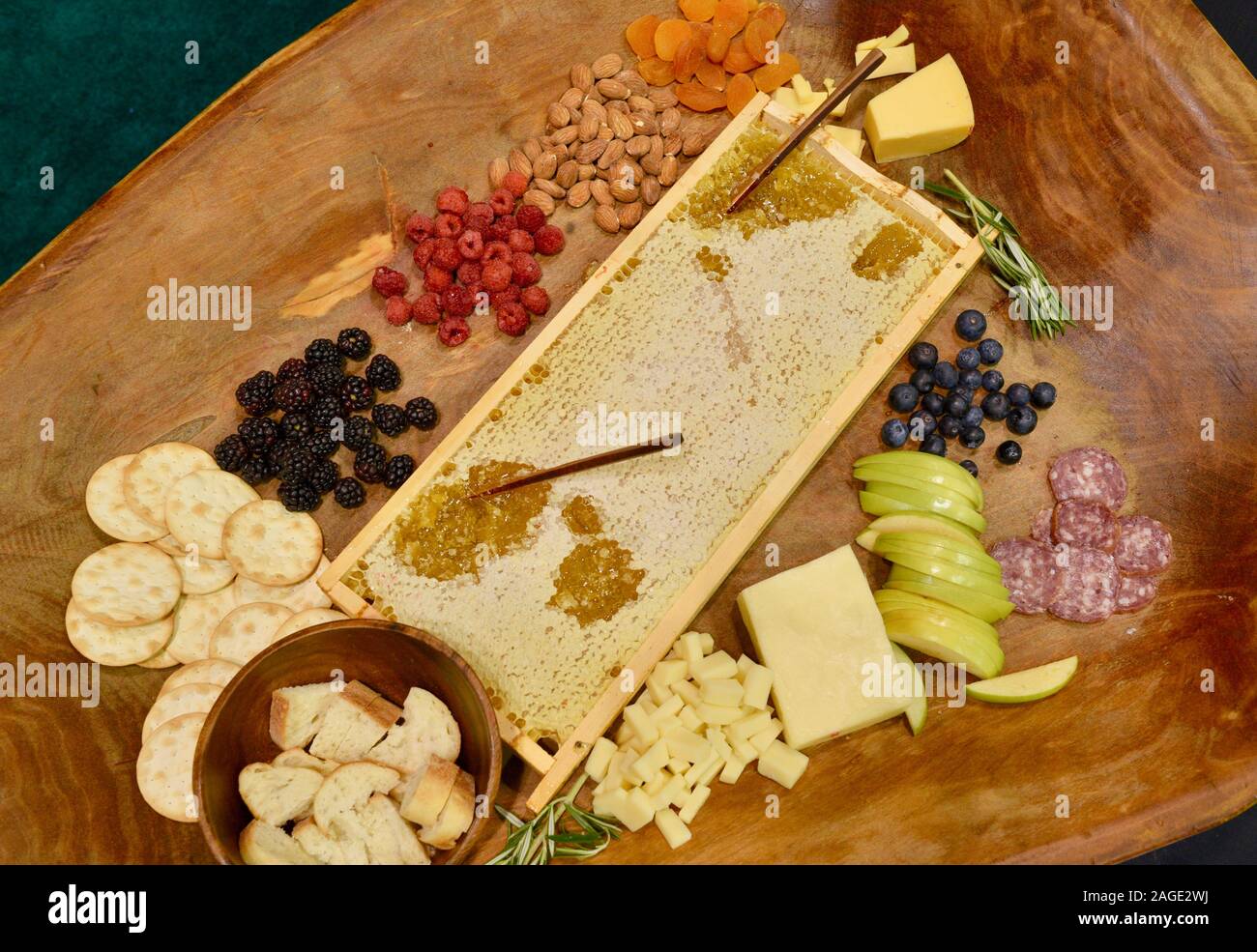 Honeycomb Honey With Fruit Nuts Cheese And Sausage On Wooden Cutting