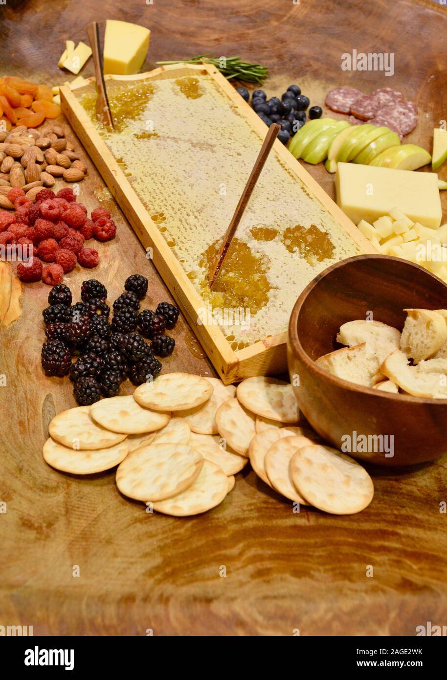 Honeycomb Honey With Fruit Nuts Cheese And Sausage On Wooden Cutting
