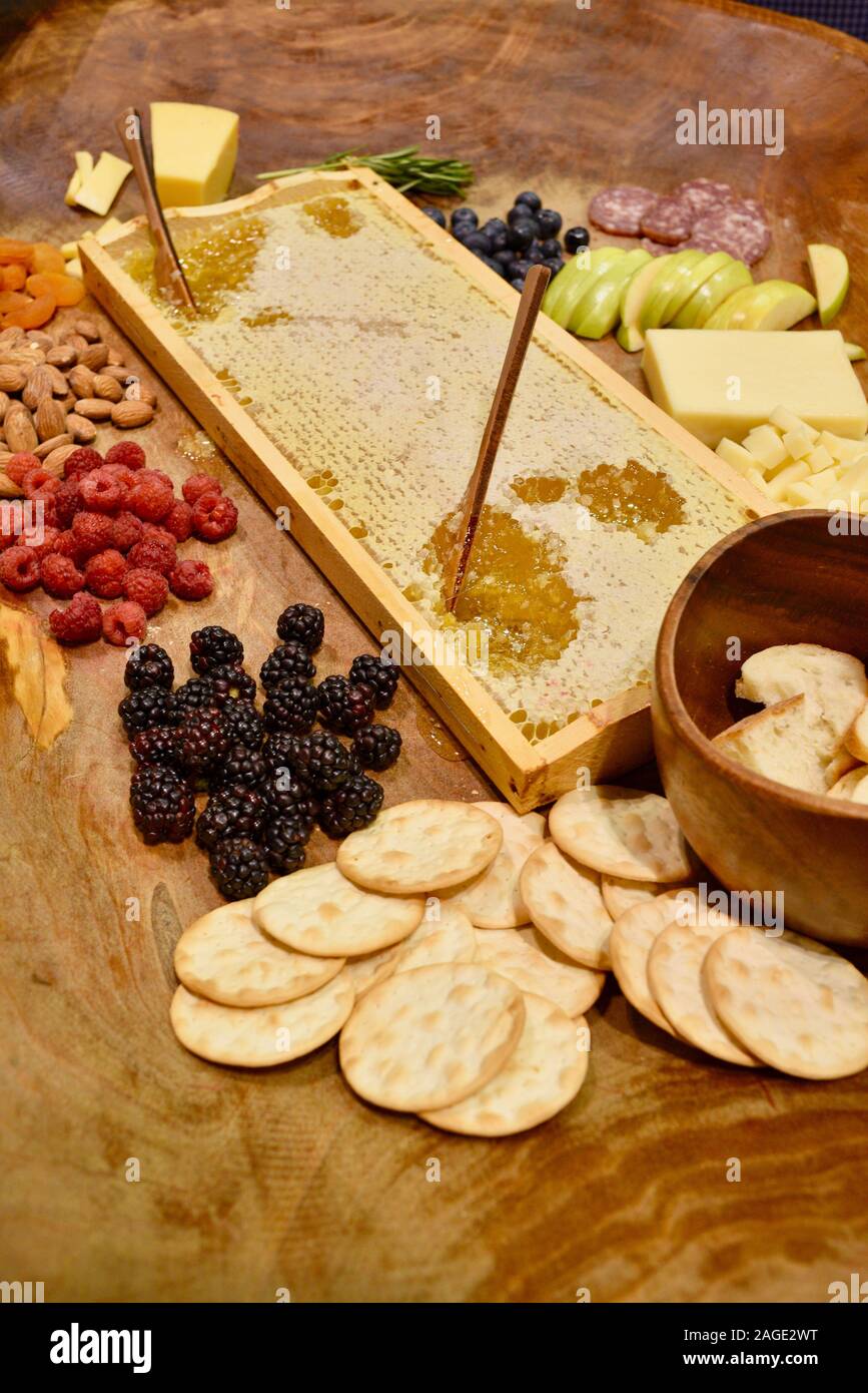Honeycomb Honey With Fruit Nuts Cheese And Sausage On Wooden Cutting