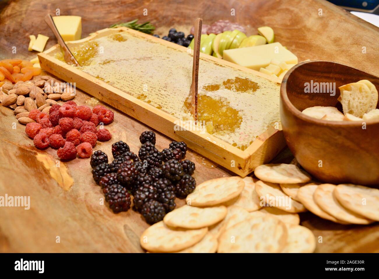 Honeycomb Honey With Fruit Nuts Cheese And Sausage On Wooden Cutting