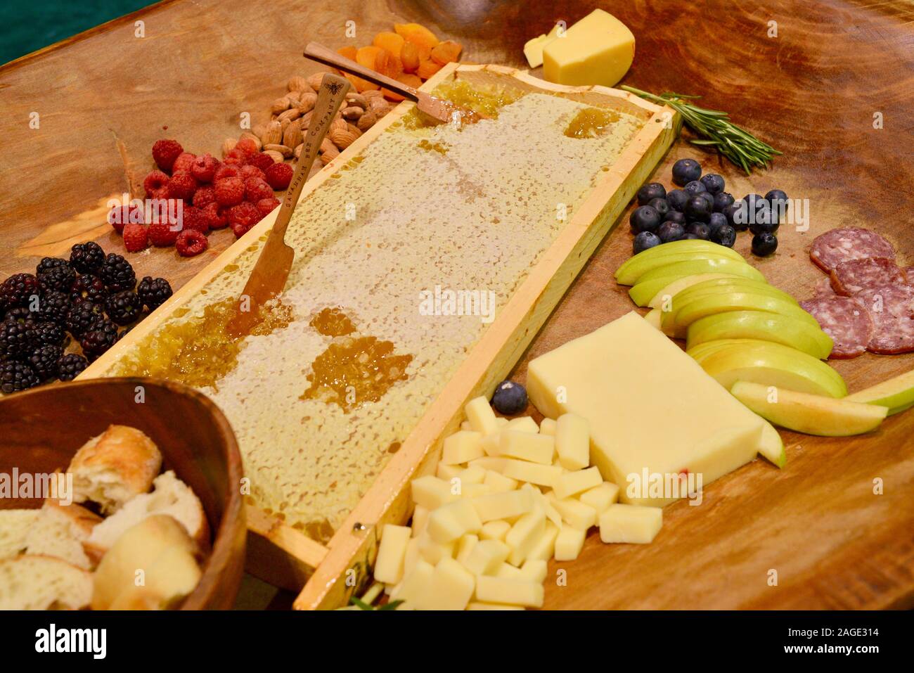 Honeycomb Honey With Fruit Nuts Cheese And Sausage On Wooden Cutting