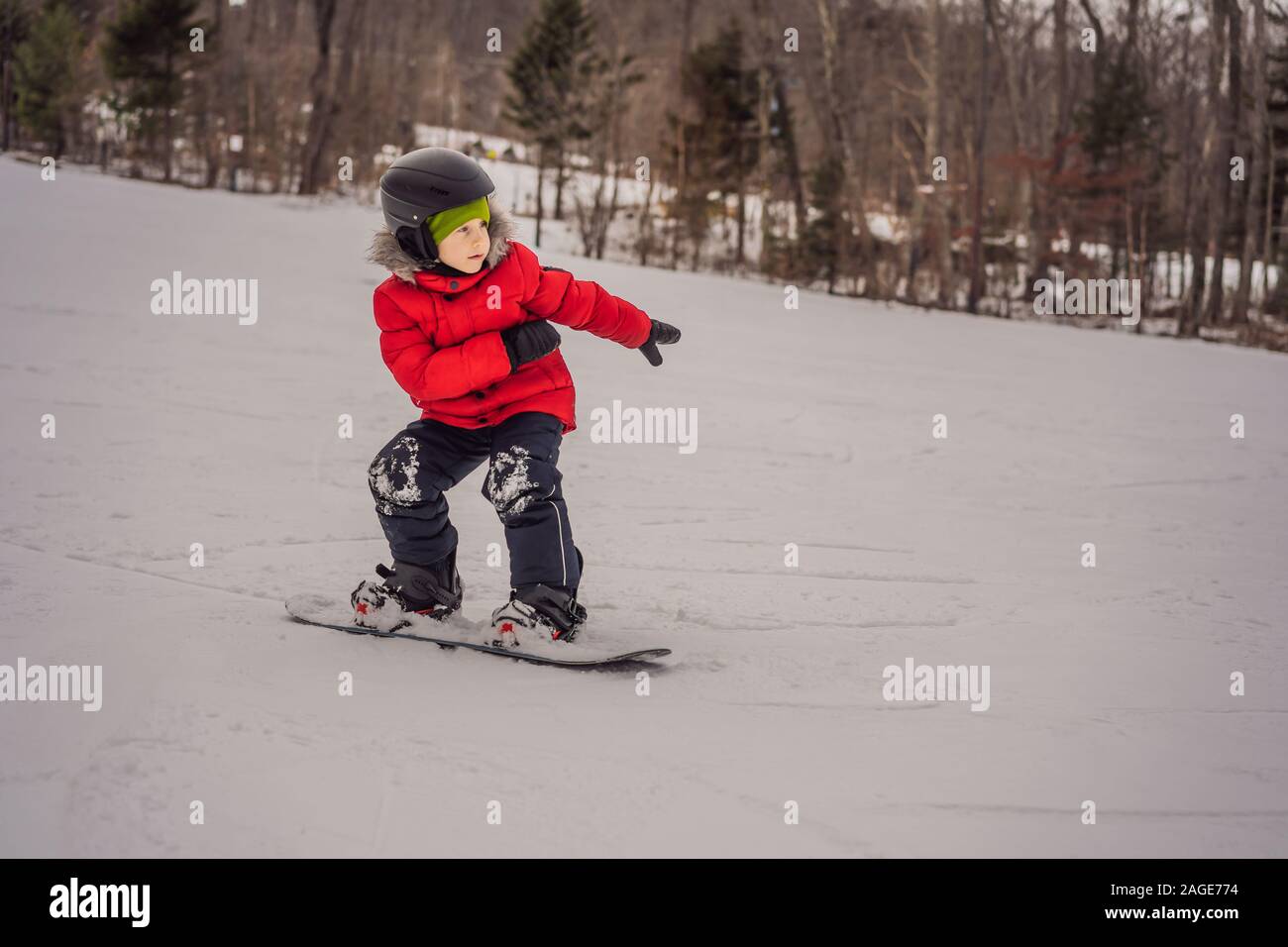 Little cute boy snowboarding. Activities for children in winter ...