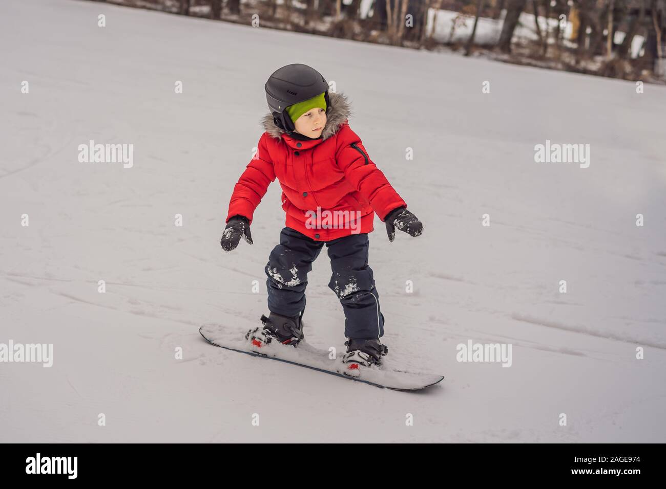 Little cute boy snowboarding. Activities for children in winter ...