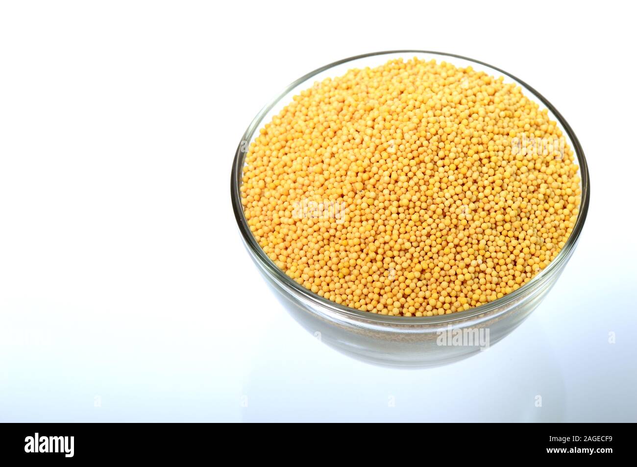 yellow mustard seeds in glass bowl isolated on white background Stock ...