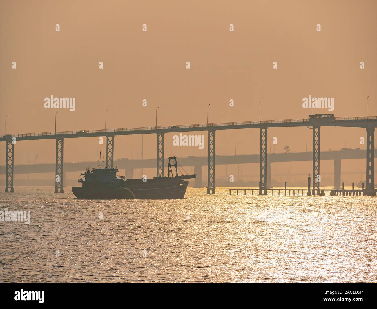 Sunset view of the cargo ship and old Macau Taipa bridge at Macau ...