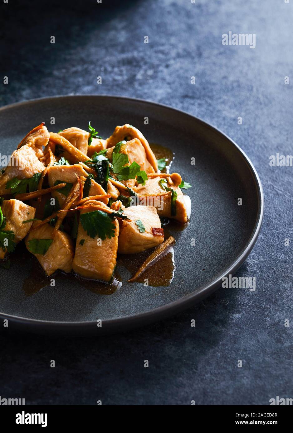 Vertical shot of grilled meat with vegetables in a black plate on a ...