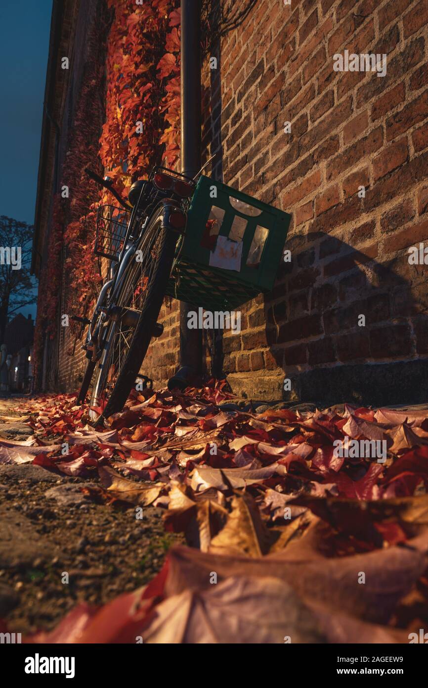 Vertical shot of a bicycle parked near the cobblestone wall on the ...