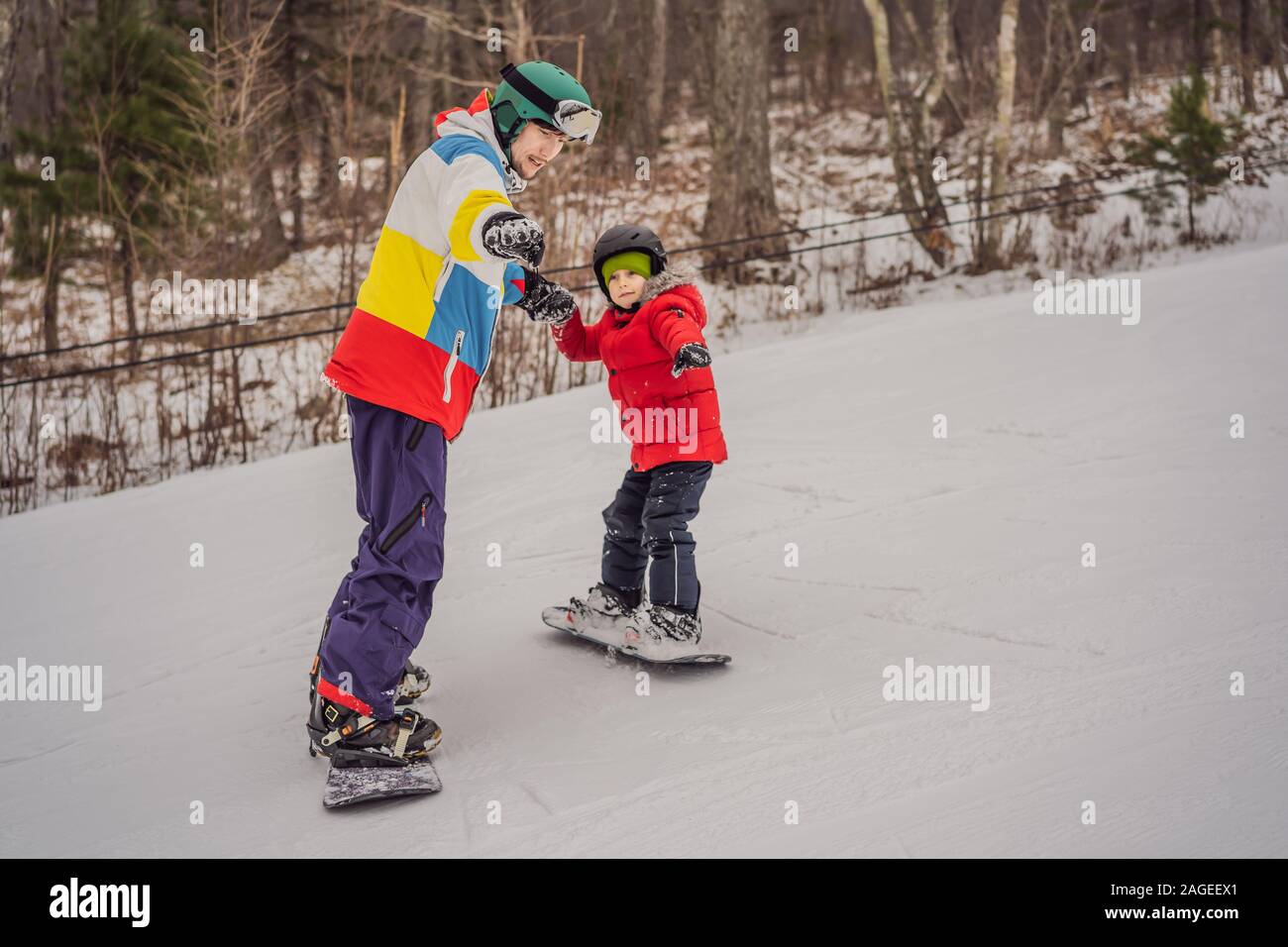 Snowboard instructor teaches a boy to snowboarding. Activities for ...