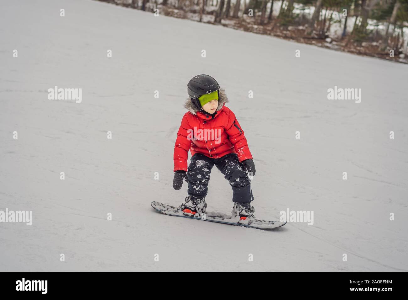 Little cute boy snowboarding. Activities for children in winter ...