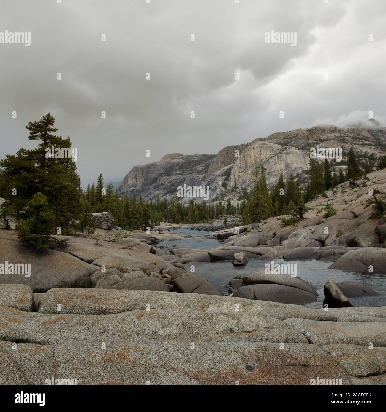 River and the stone under the dark cloudy sky in the Yosemite National ...