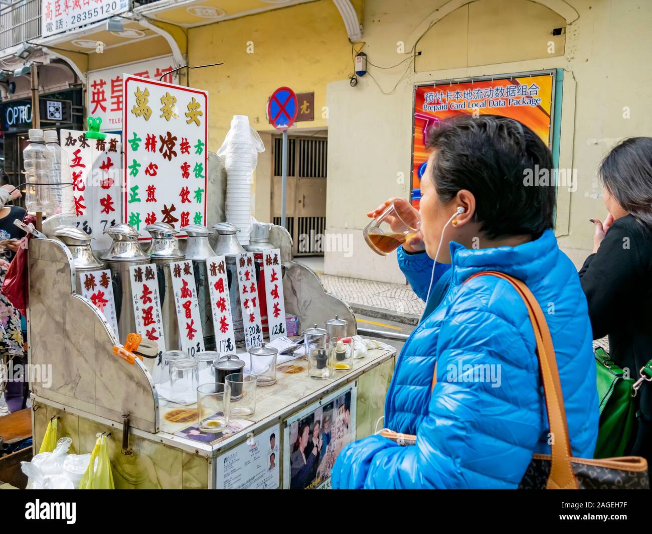 Macau, DEC 25: Woman drinking traditional herb tea from street vendor ...