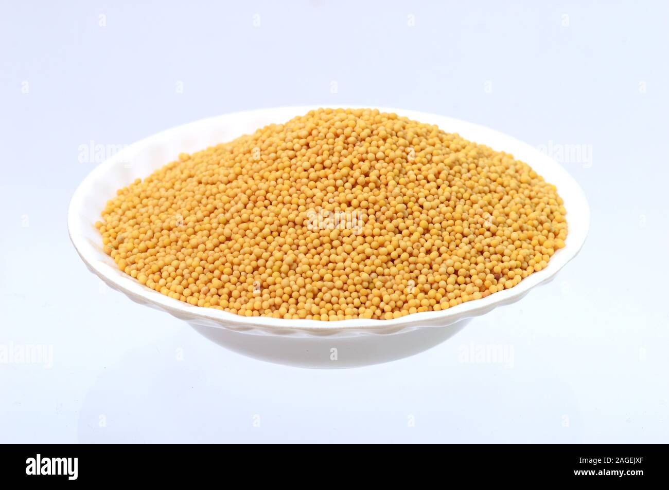 yellow mustard seeds in plate isolated on white background Stock Photo ...