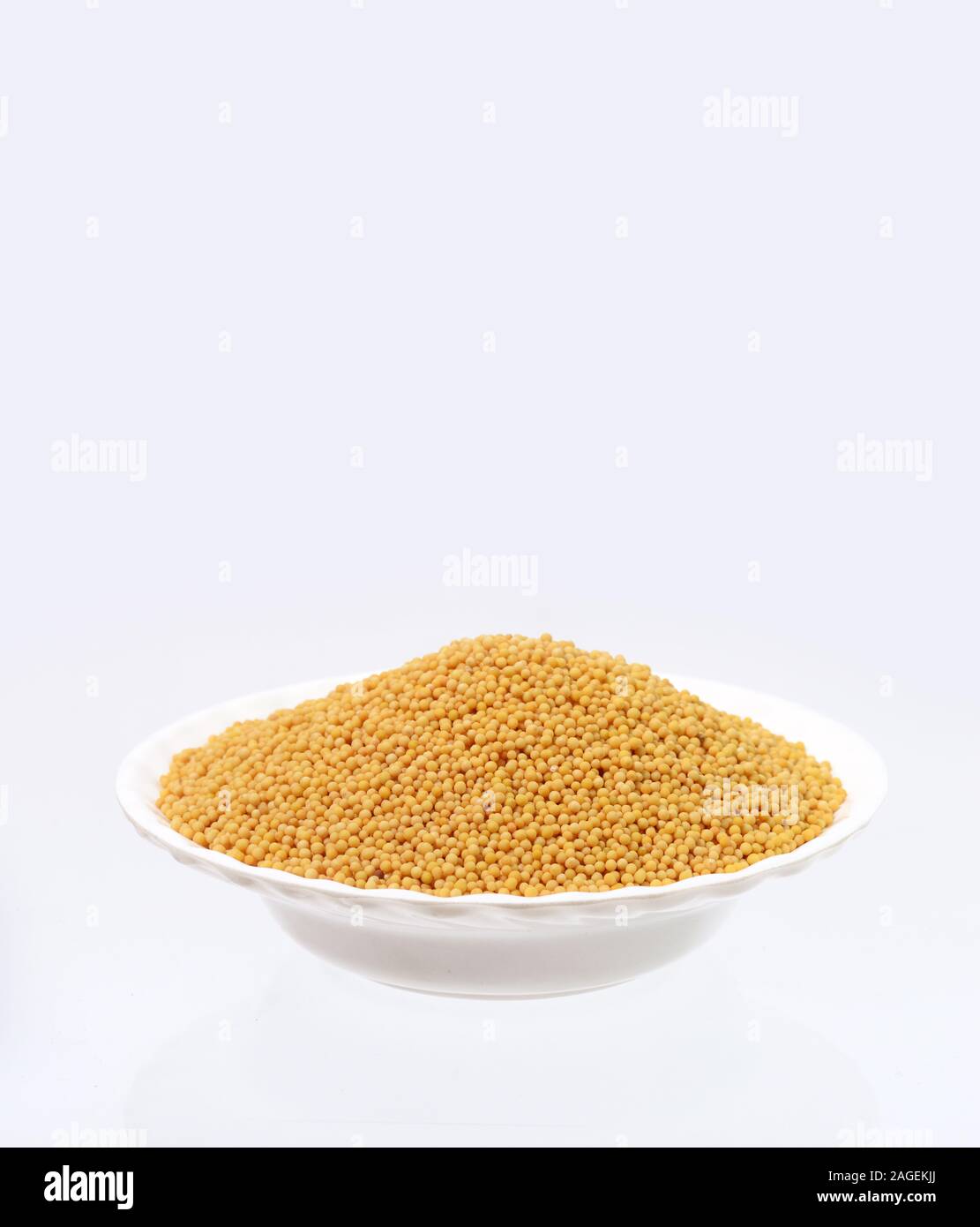 yellow mustard seeds in plate isolated on white background Stock Photo ...