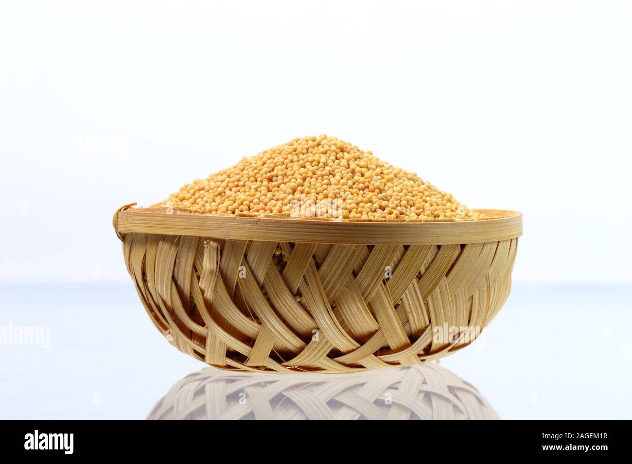 yellow mustard seeds in wooden basket isolated on white background ...