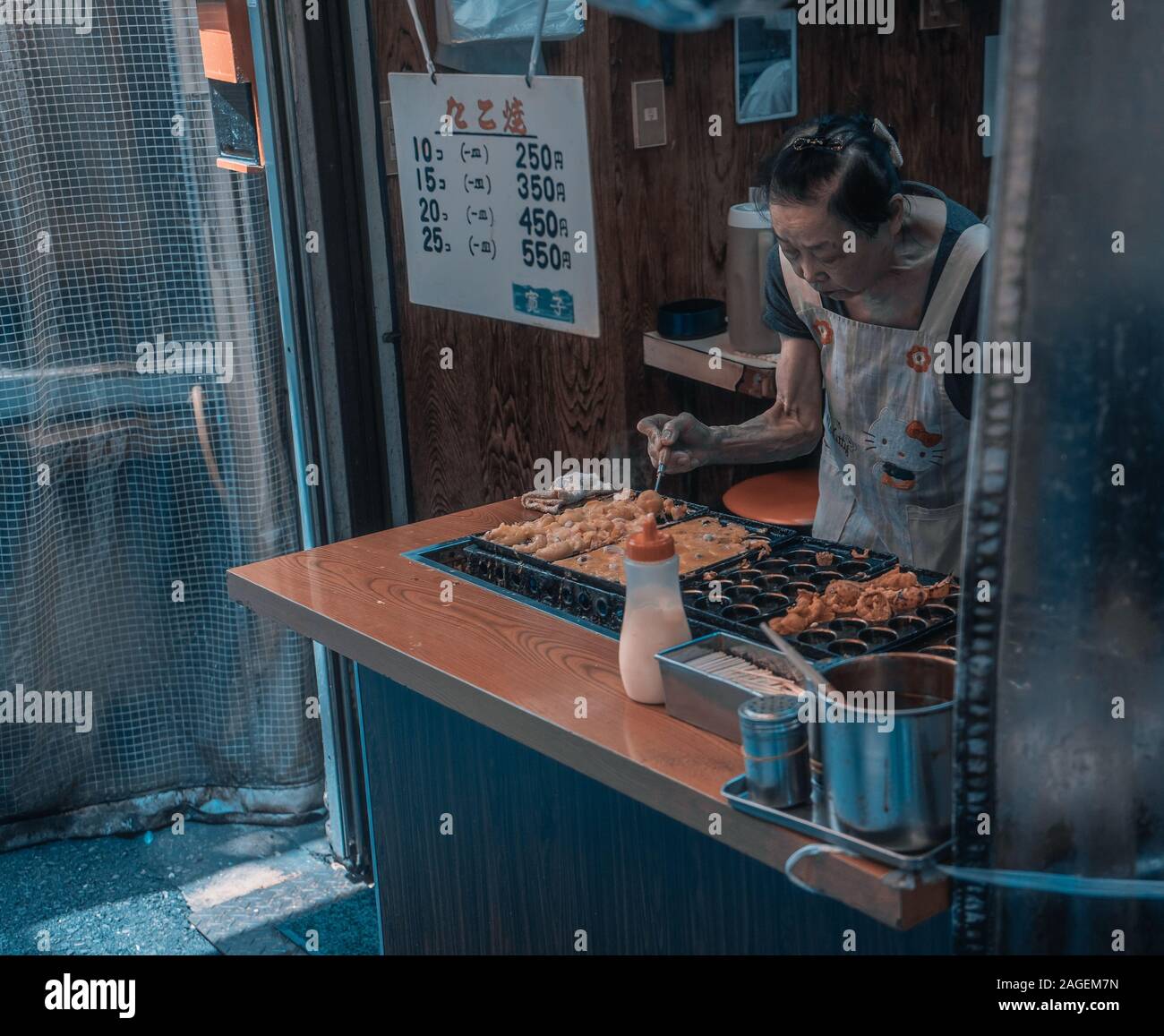 OSAKA, JAPAN - Aug 12, 2019: old woman making takoyaki in shop Stock ...