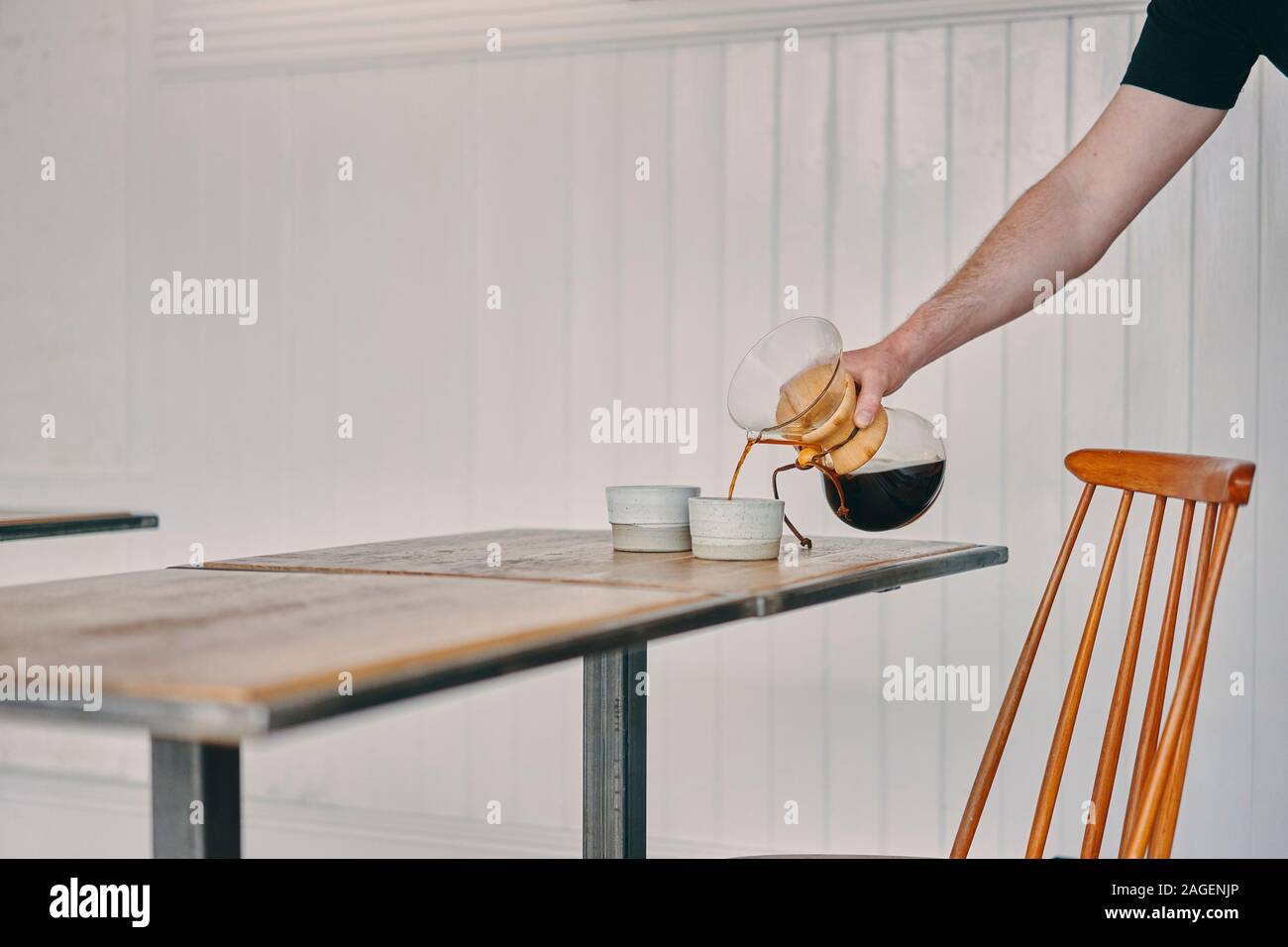 Waiter pouring coffee into cups on table in restaurant Stock Photo - Alamy